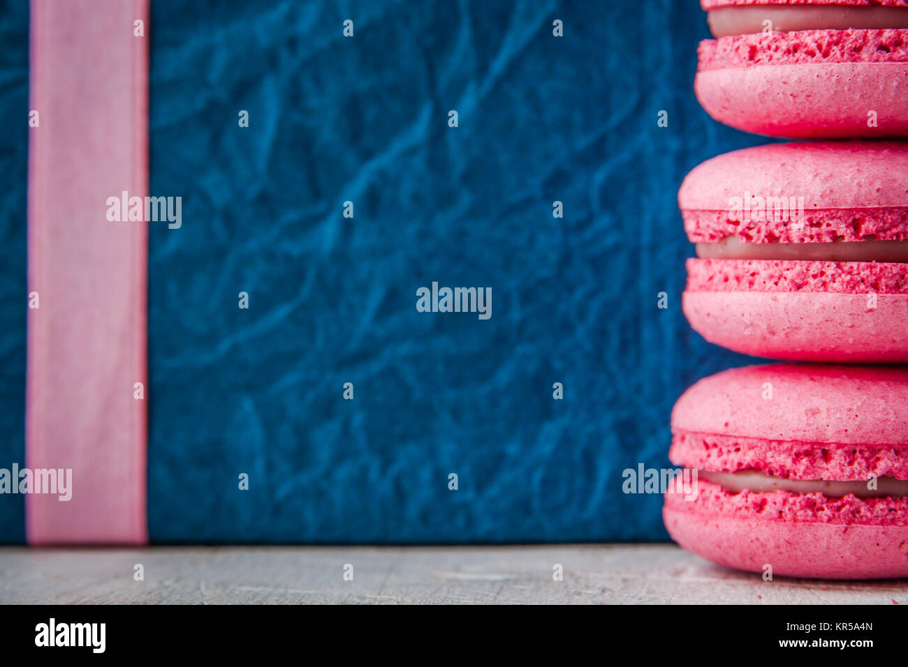 Pink macaroon on a blue background Stock Photo - Alamy