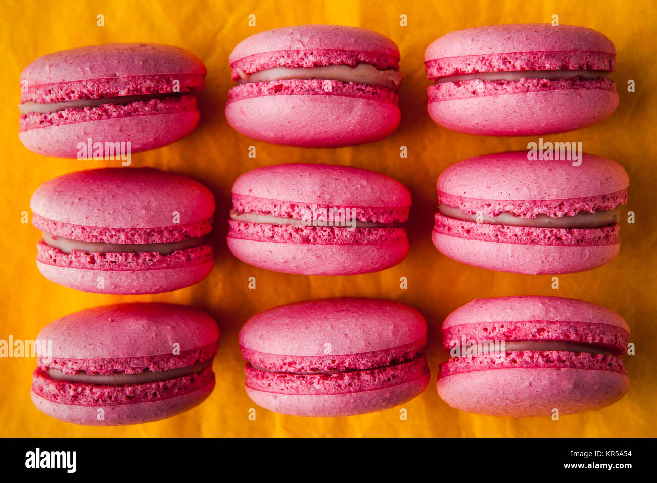 Pink macaroon on a yellow tablecloth Stock Photo - Alamy