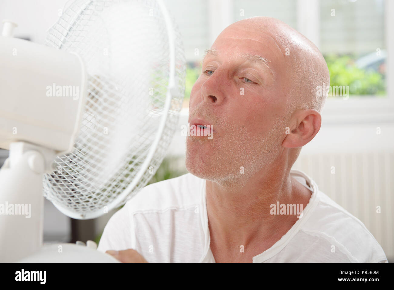 mature man refreshed with a fan Stock Photo - Alamy