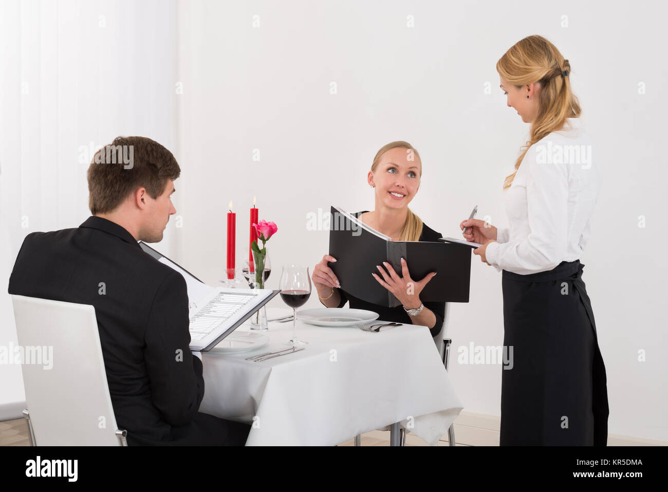 Waitress Taking An Order From A Happy Couple Stock Photo - Alamy