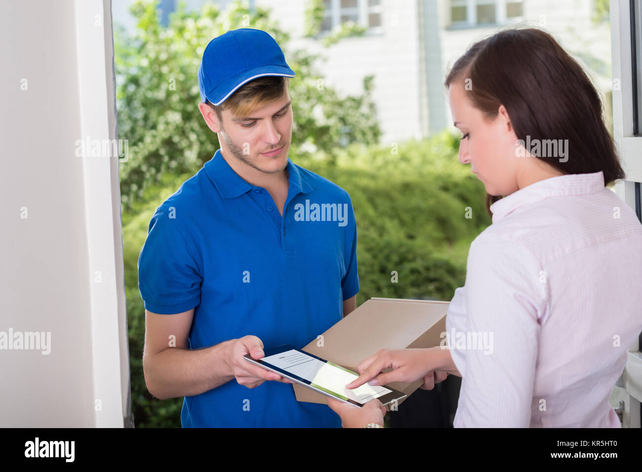 Woman Signing Receipt Of Delivery Package Stock Photo - Alamy