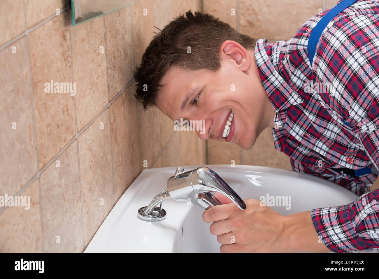 Plumber Fixing Tap Of Sink Stock Photo - Alamy