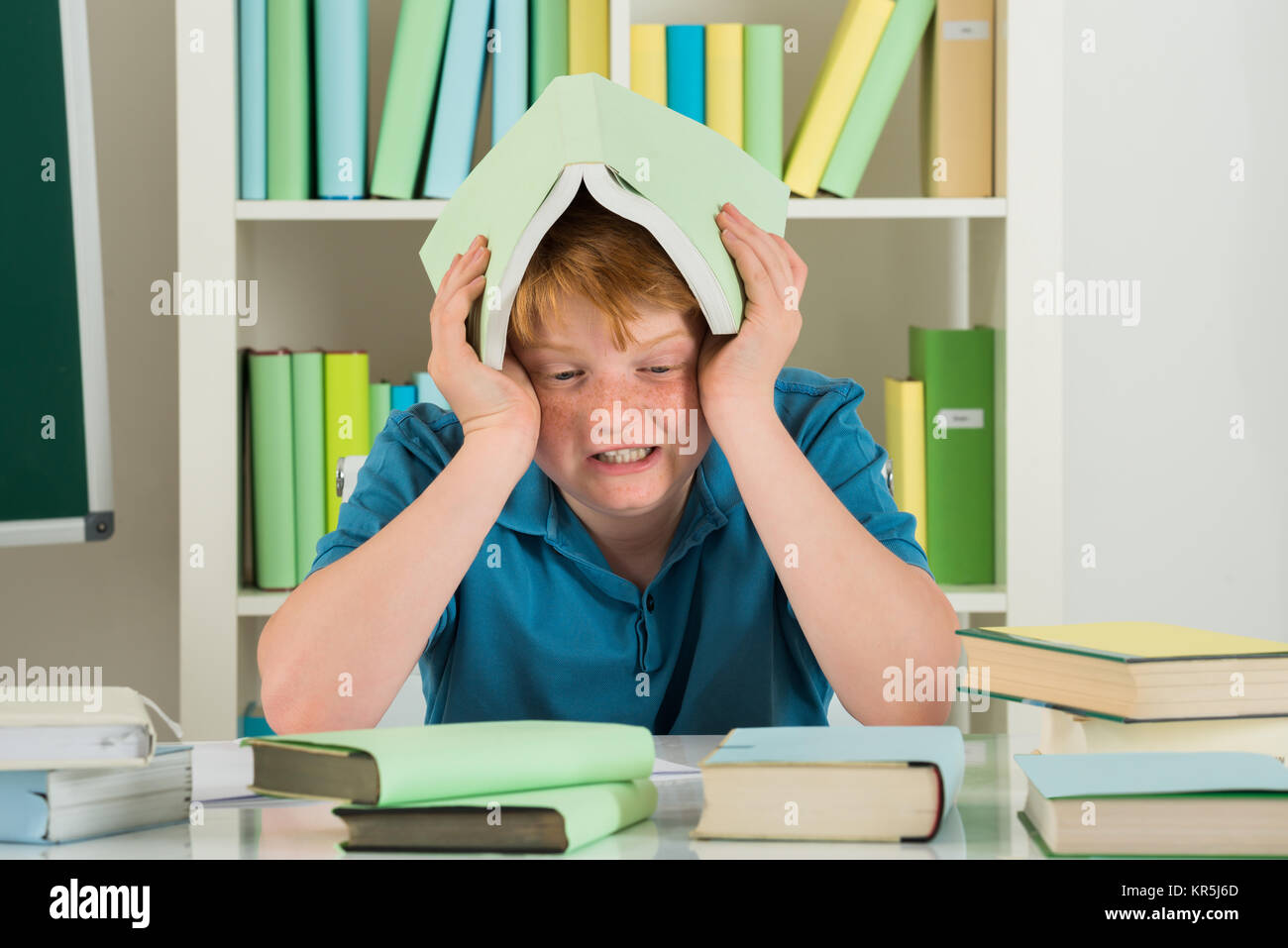 Angry Boy Sitting In Library Stock Photo - Alamy