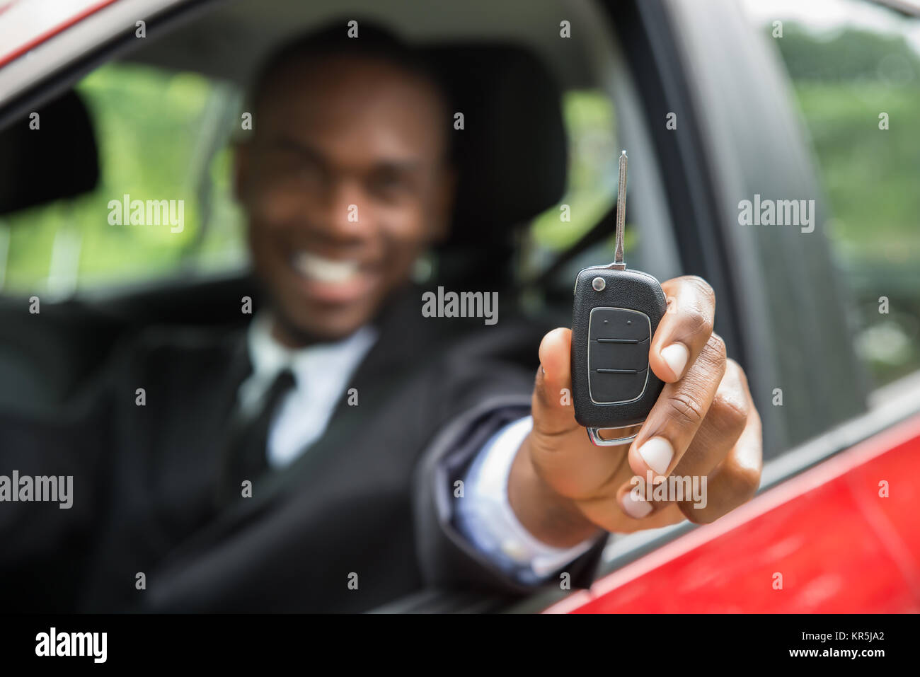Businessman Sitting In A Car Showing Car Key Stock Photo - Alamy