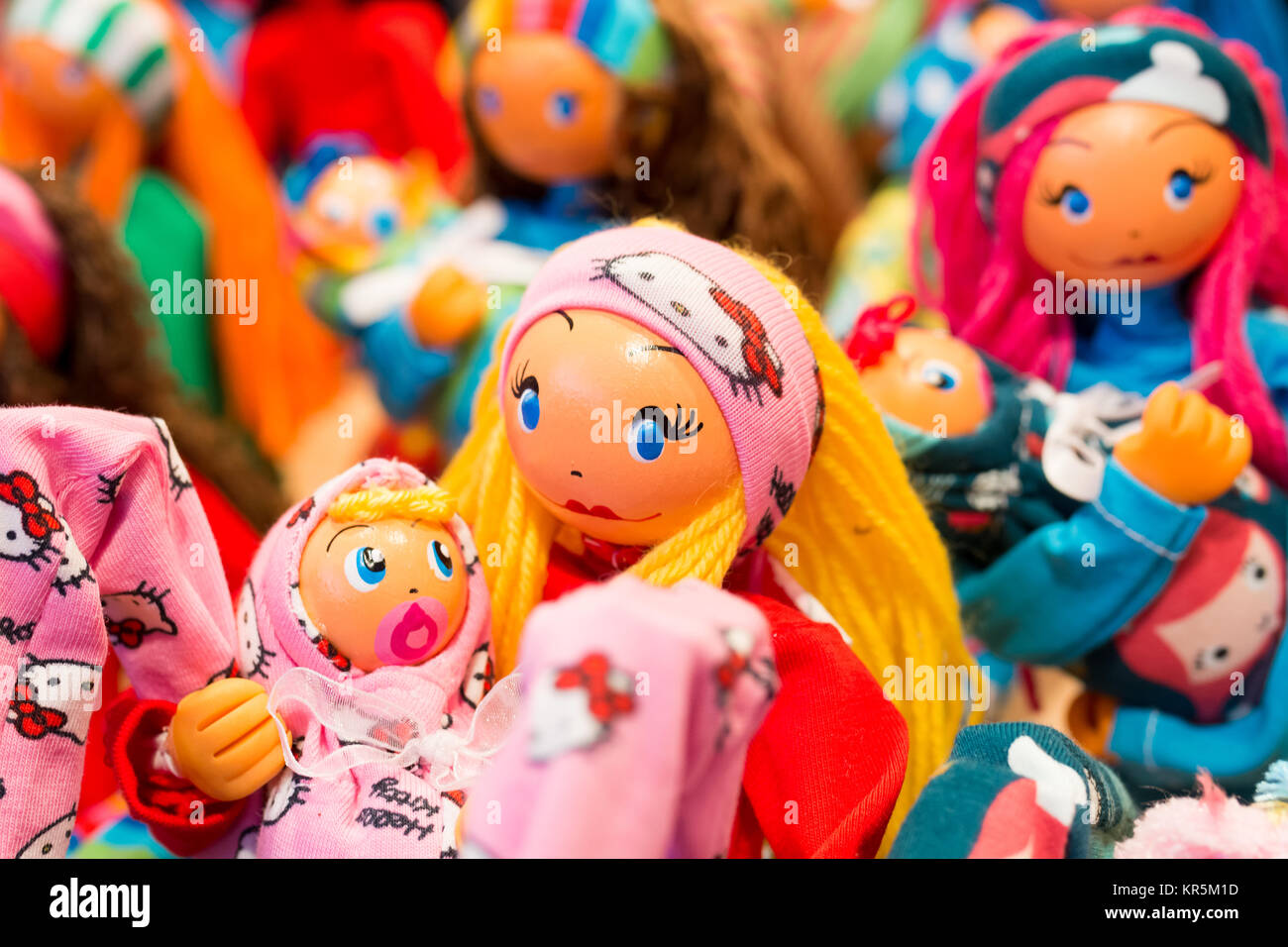 A display of toy rag dolls made from wood and bright colorful cloth ...