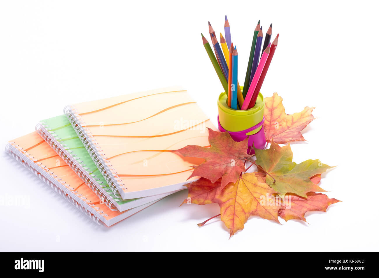 Writing-books, multi-coloured pencils and autumn leaves Stock Photo - Alamy