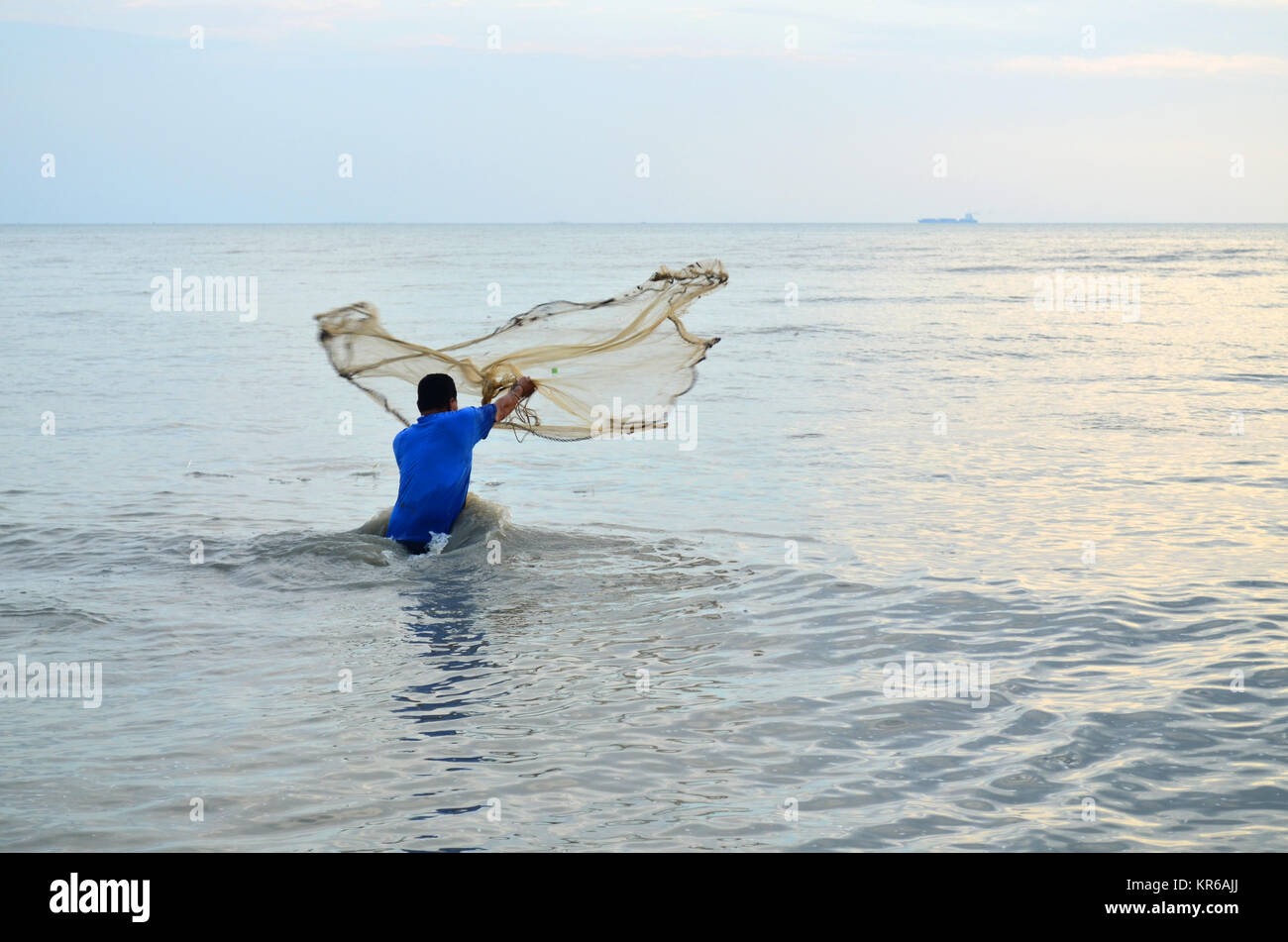 asian adult man throwing fish net to catch fish.malaysian fisherman ...