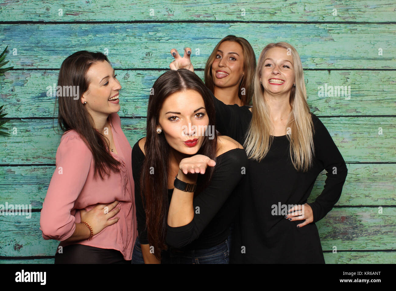 4 pretty girls silly in front of a photo box Stock Photo - Alamy