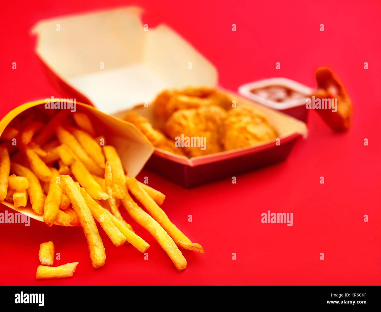 chicken nuggets and french fries on red background Stock Photo - Alamy