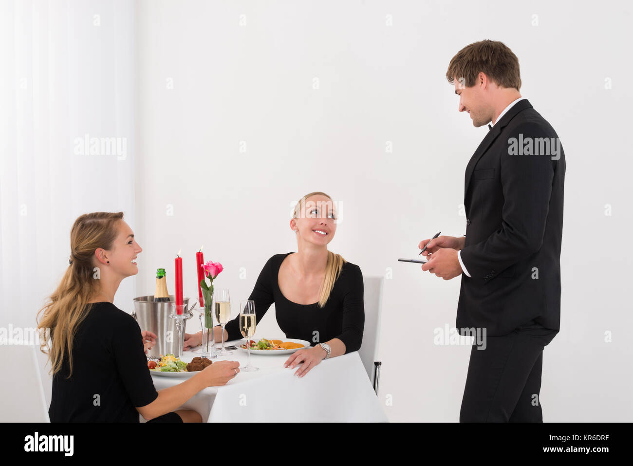 Waiter Taking An Order From Female Friends Stock Photo - Alamy