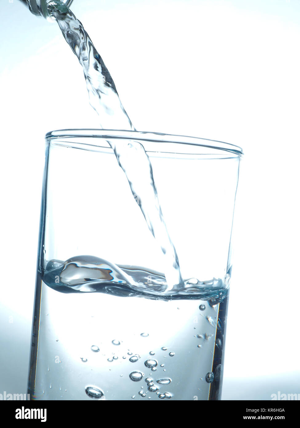 Pouring fresh table water in a glass, blue toned healthy concept image ...
