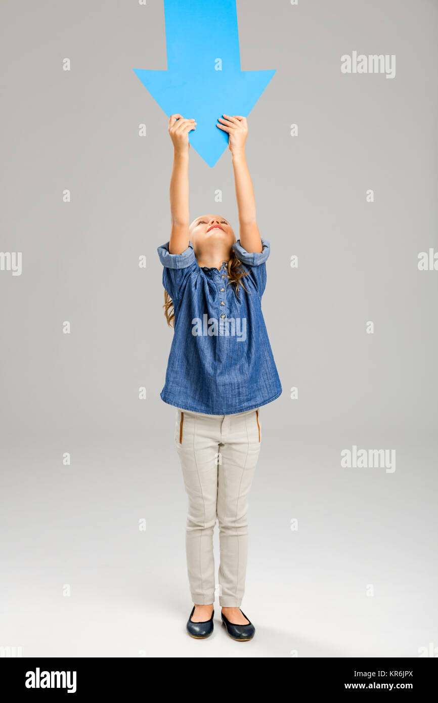 Girl holding a big blue arrow Stock Photo - Alamy