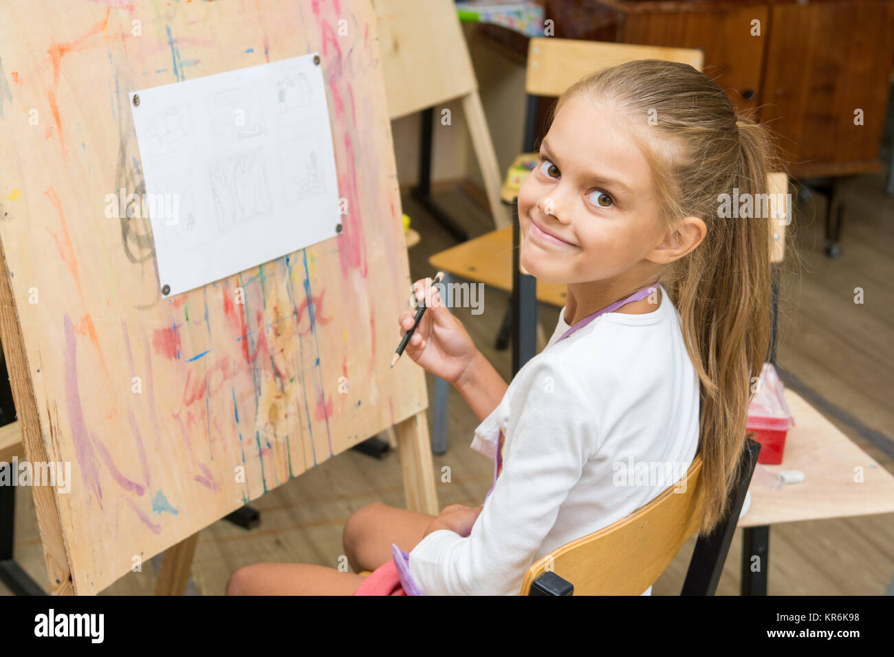 Girl happily looks into the frame on a drawing lesson Stock Photo - Alamy