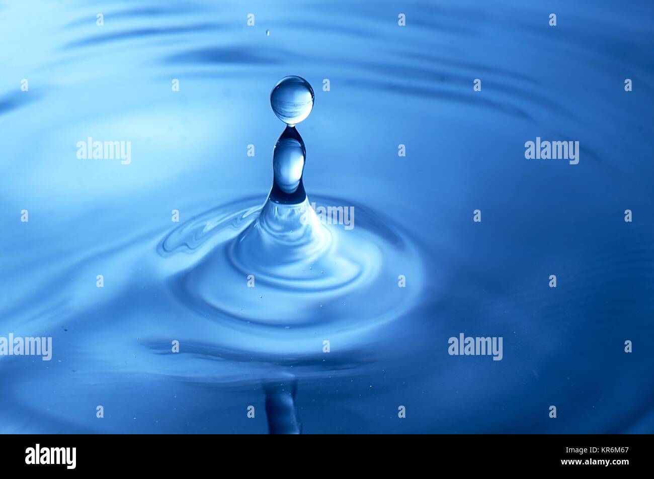 Drop of water splashed creates waves Stock Photo - Alamy