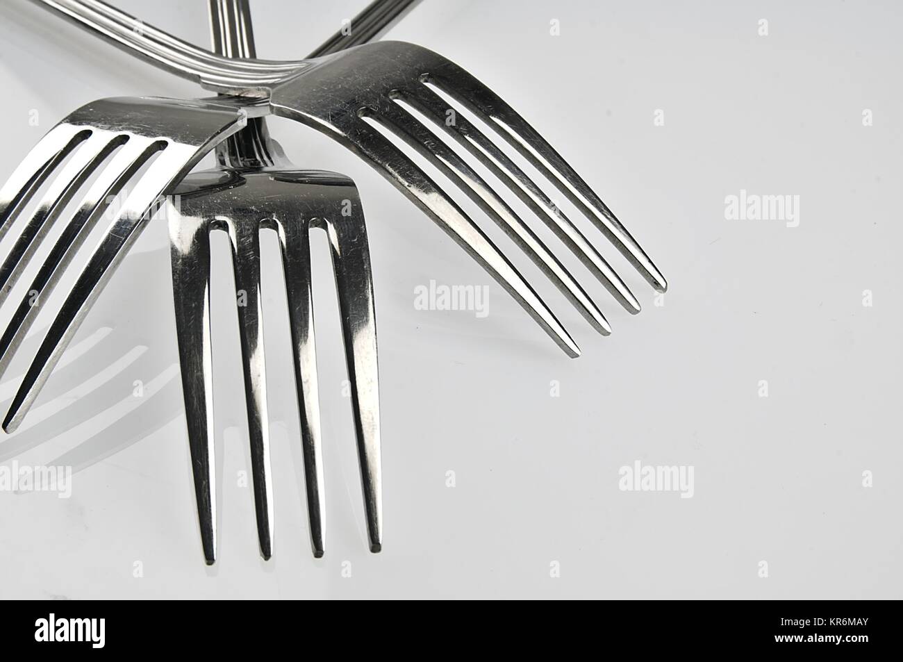 Forks arranged in series on the kitchen table Stock Photo - Alamy