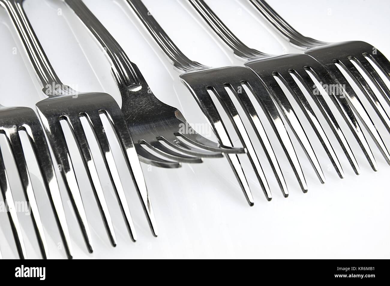 Forks arranged in series on the kitchen table Stock Photo - Alamy