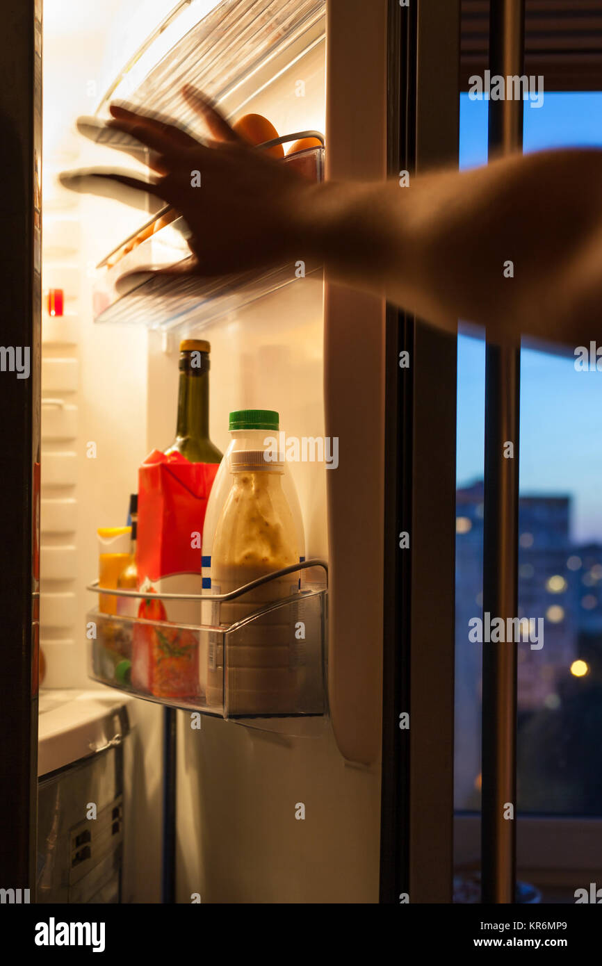 hand goes for food in refrigerator in eveving Stock Photo - Alamy