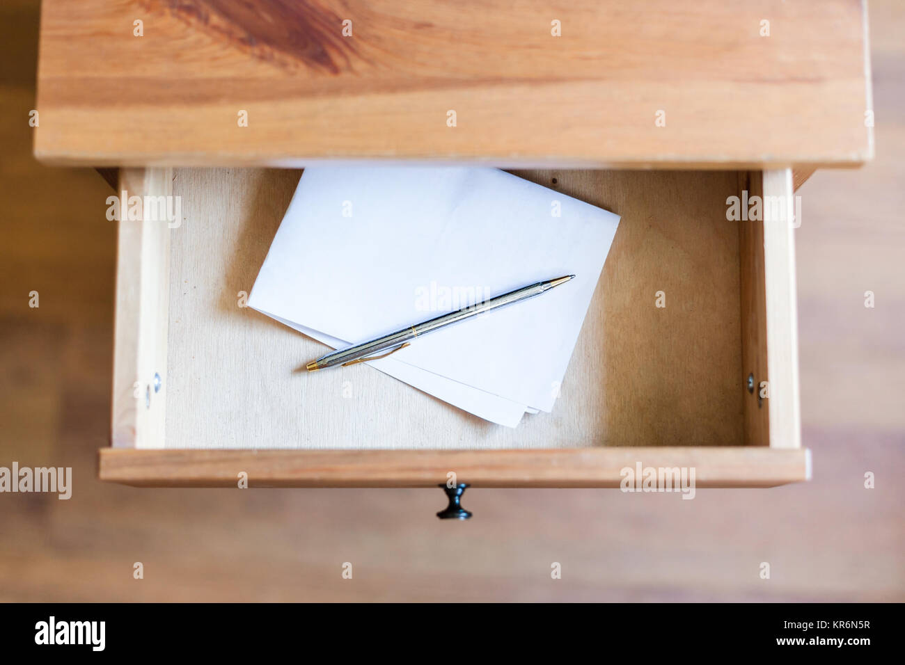 folded sheet of paper and pen in open drawer Stock Photo - Alamy