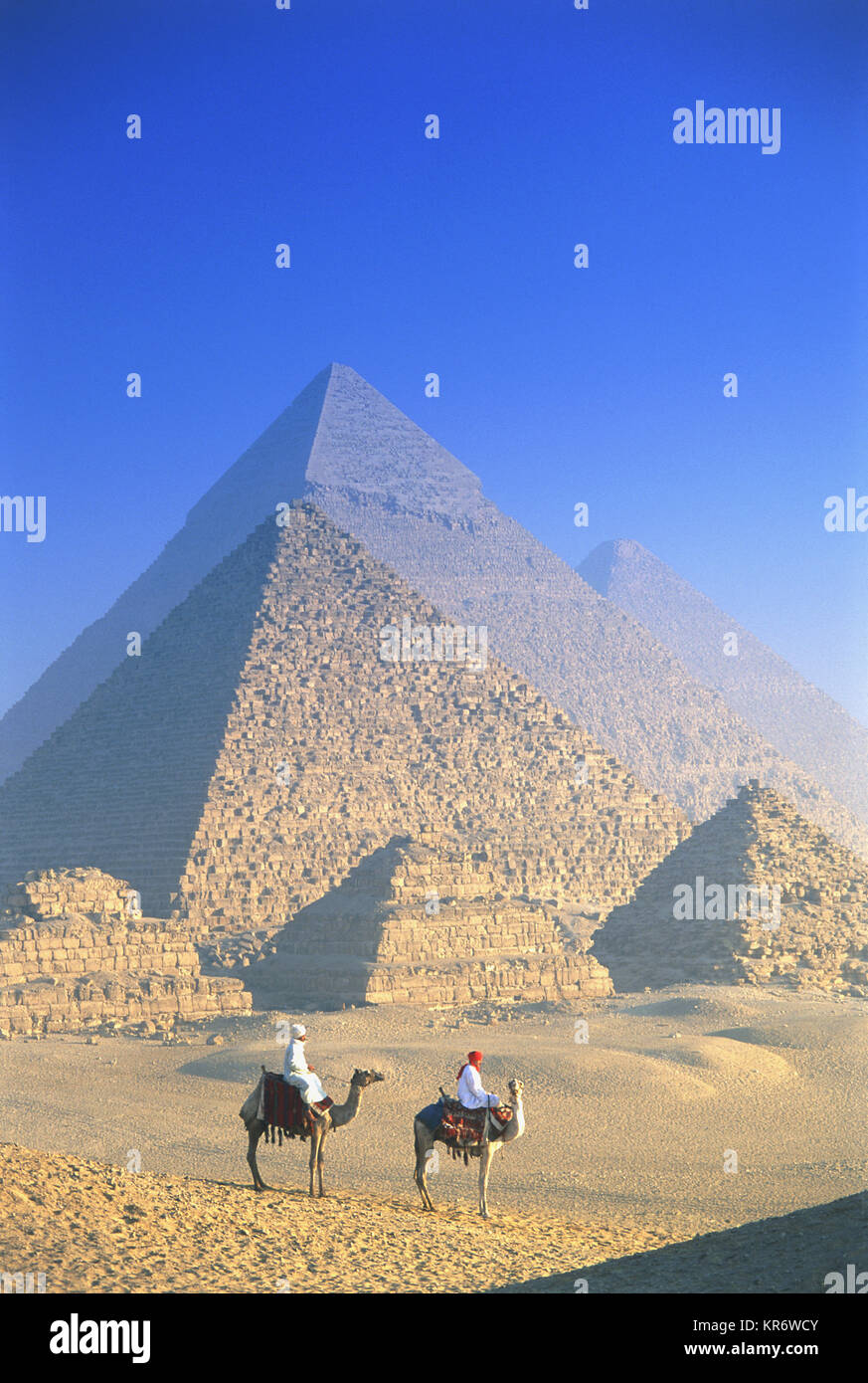 Two people on camels in front of Egyptian pyramids Stock Photo - Alamy