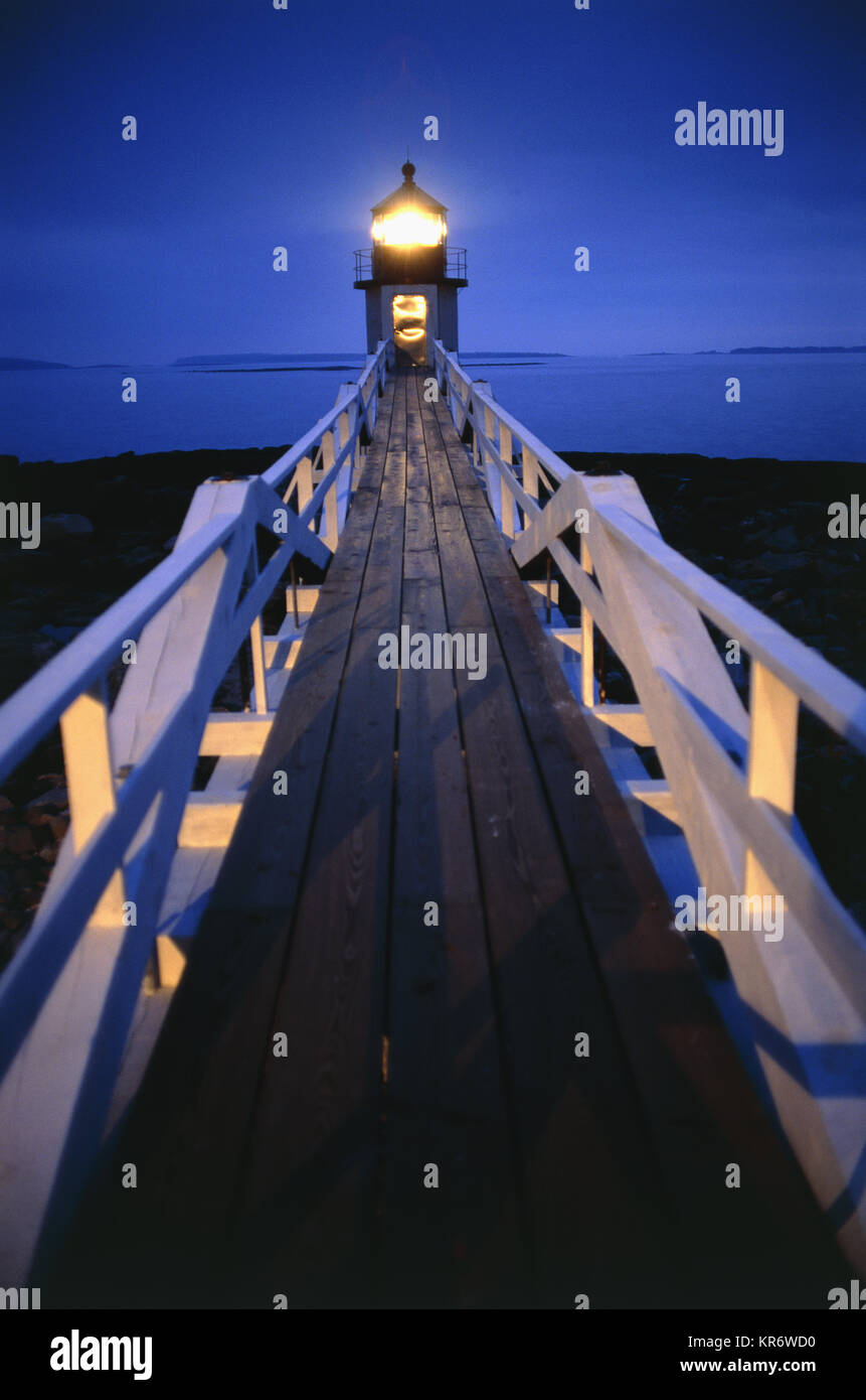 Illuminated wooden walkway towards lighthouse in the evening Stock ...