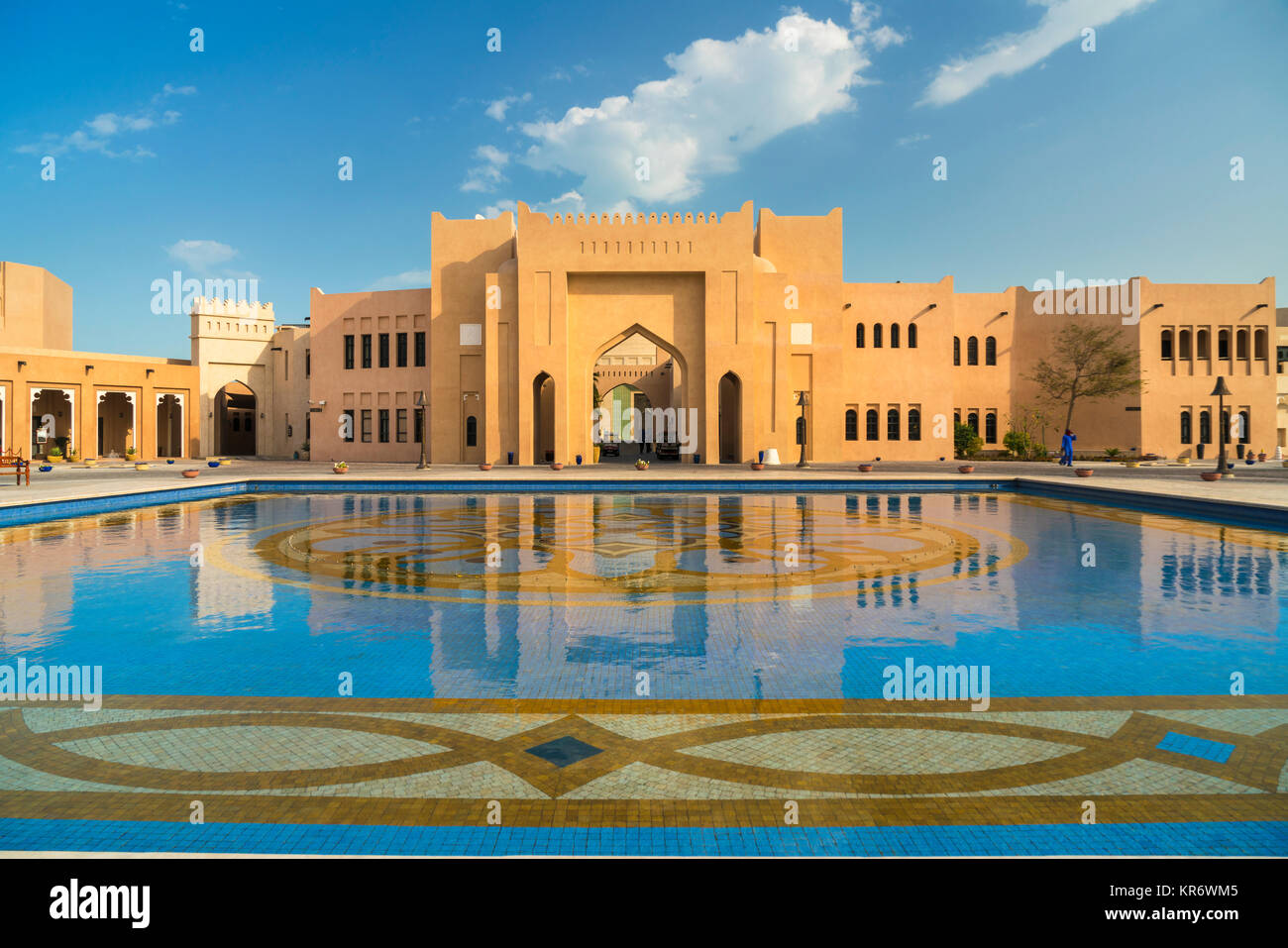 Facade of Middle Eastern building, pond with blue and golden mosaic ...