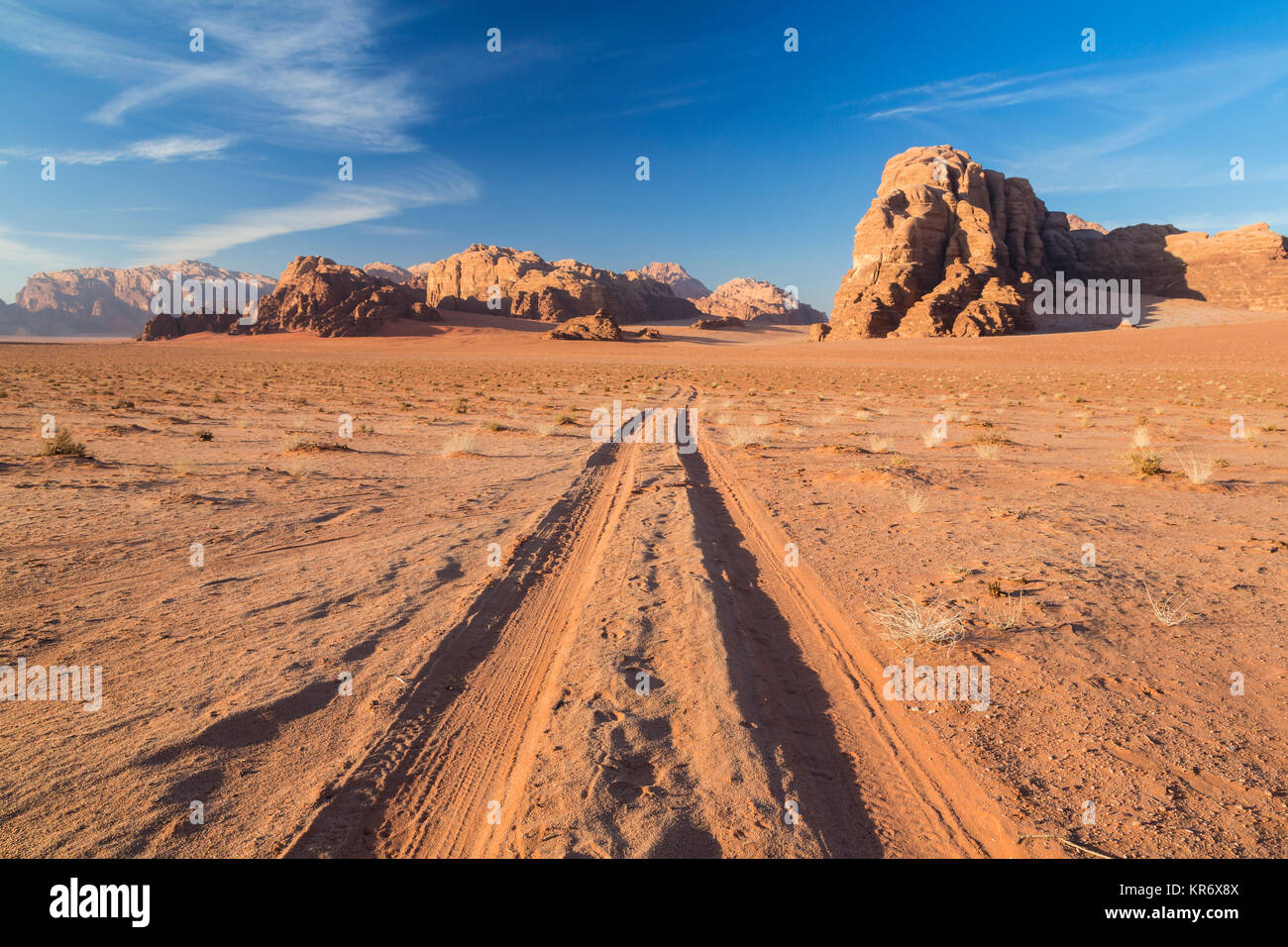 Desert landscape with tire tracks leading to distant mountain Stock ...