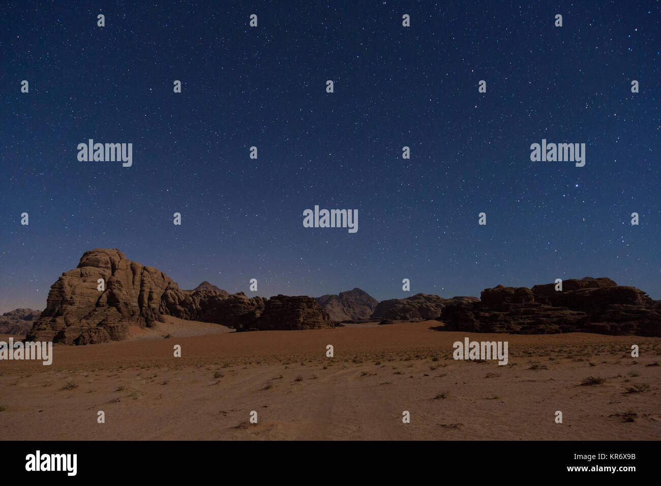 Desert landscape with rocks and mountains under a starry sky in the ...
