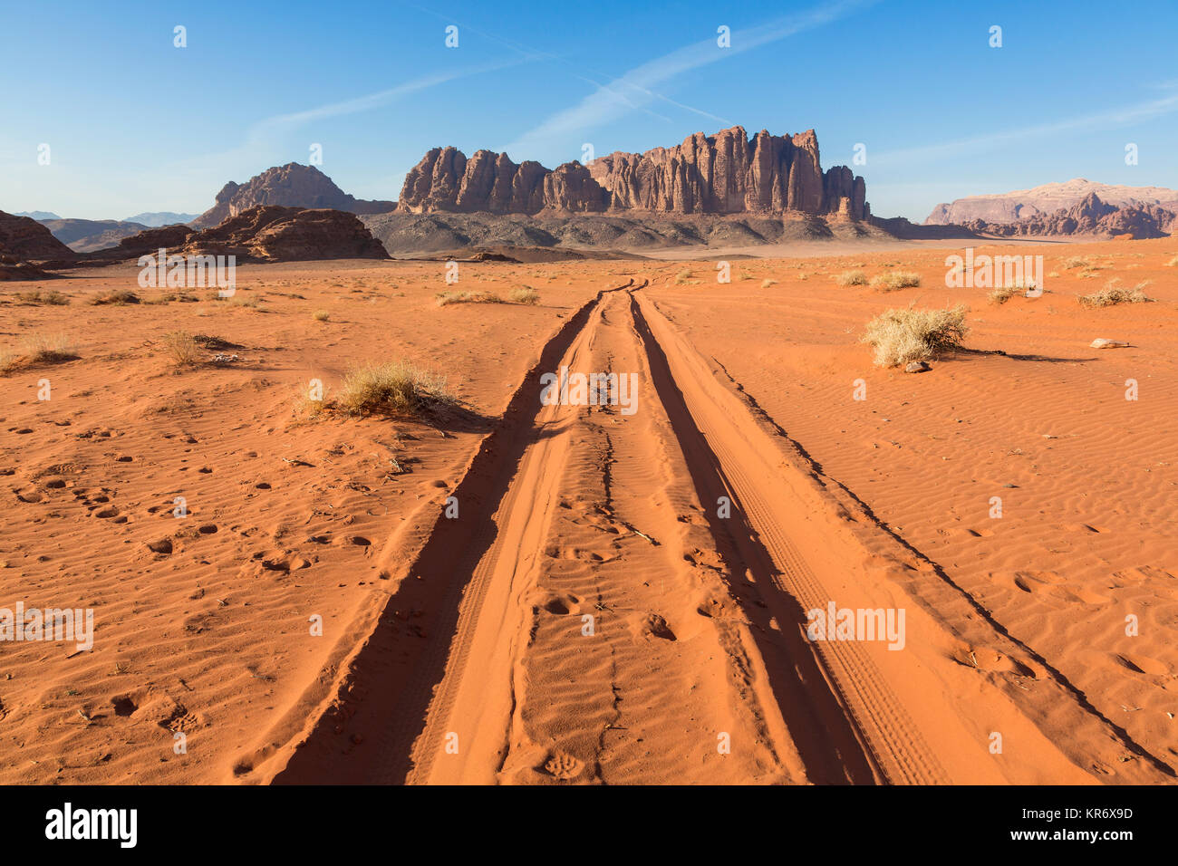 Desert landscape with tire tracks leading to distant mountain Stock ...
