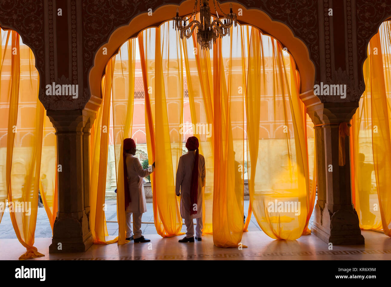 Two men wearing traditional clothing and turbans standing under arch ...