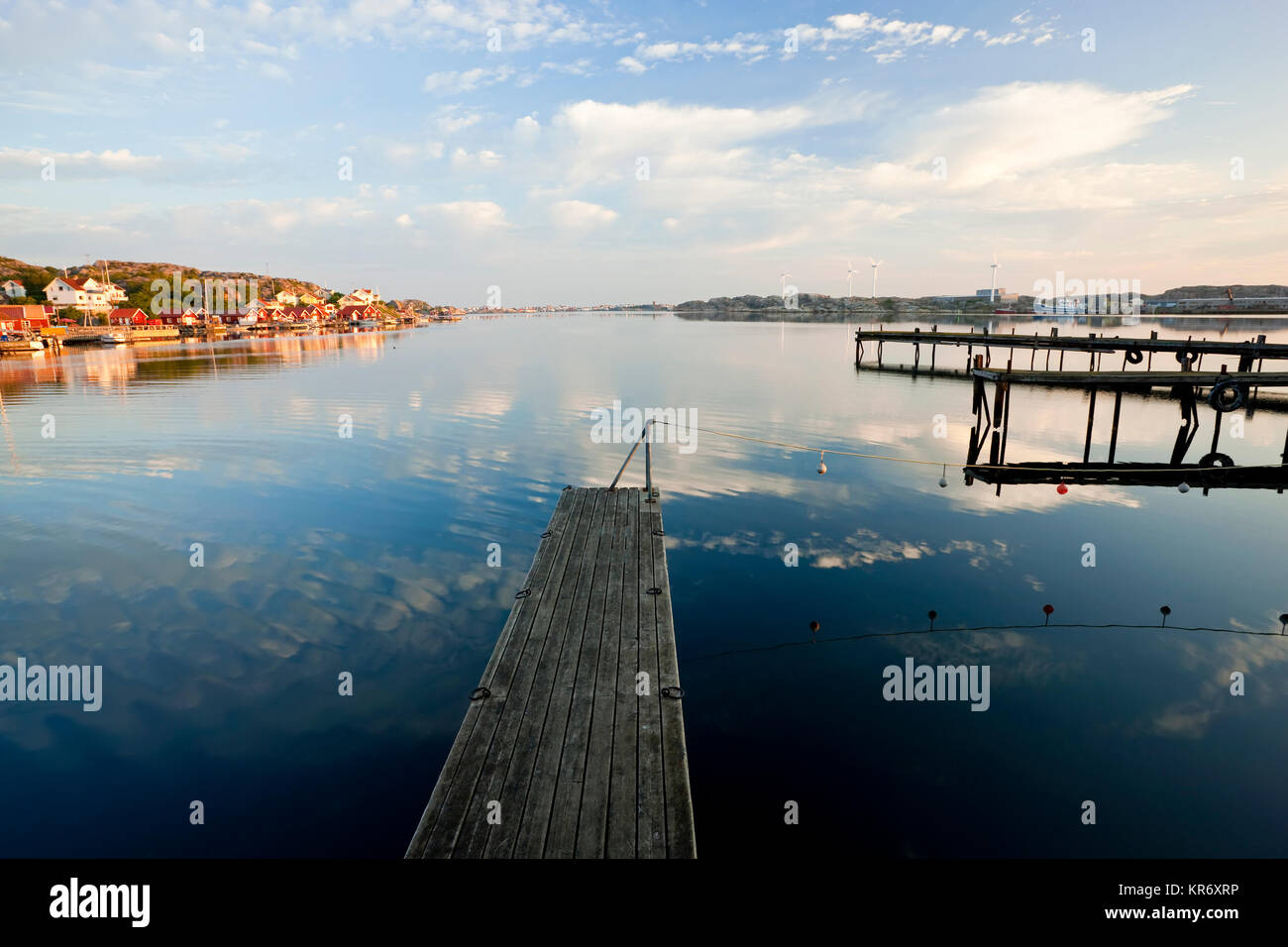 View along a wooden pier over water, buildings in the distance Stock ...