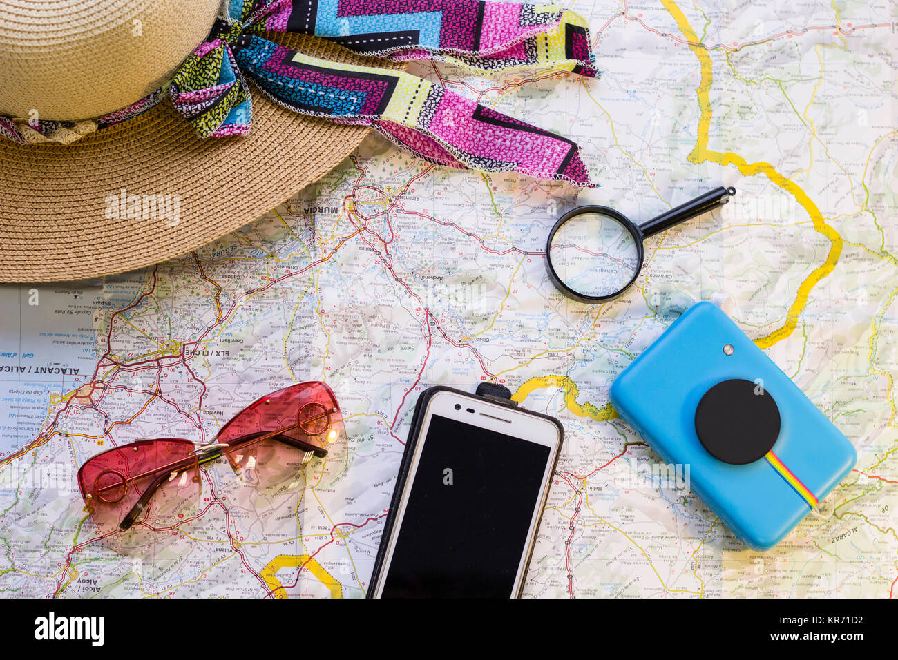 Traveler items on a map - a straw hat, a mobile phone, sunglasses, a ...