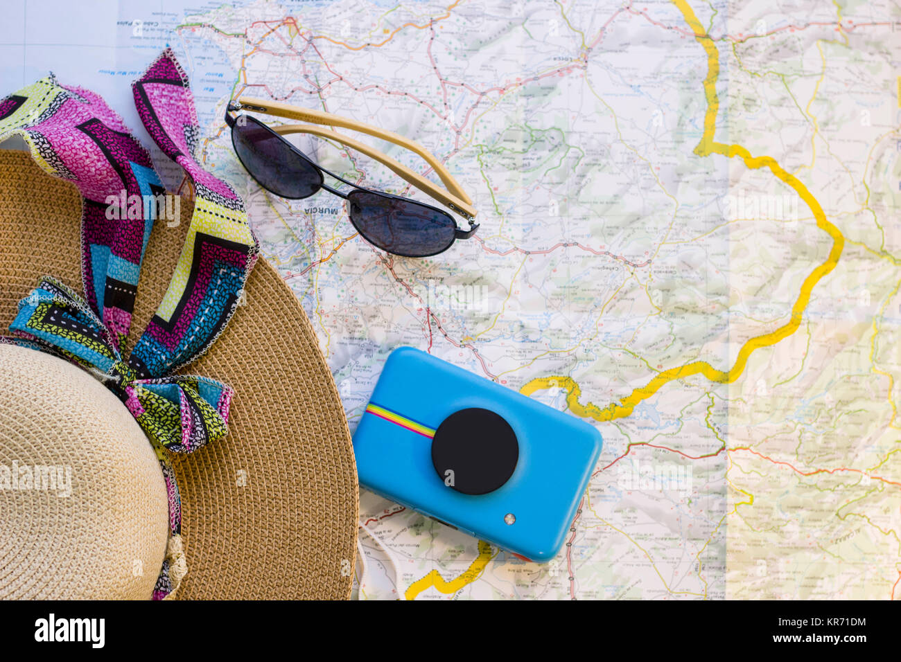 Traveler items on a map - a straw hat, sunglasses, a camera and a ...