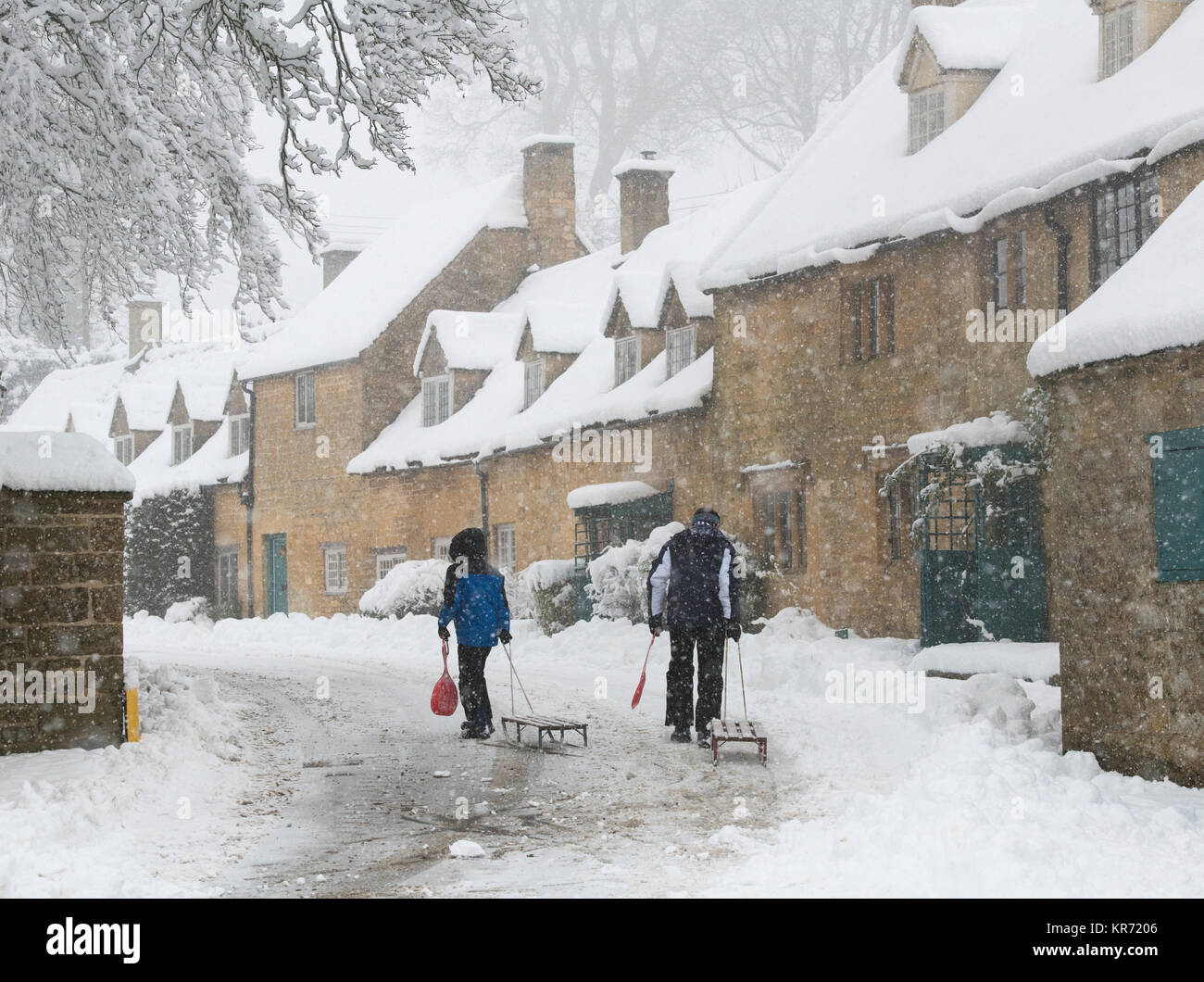 Teenage boys pulling sledges in Snowshill village in the december snow ...