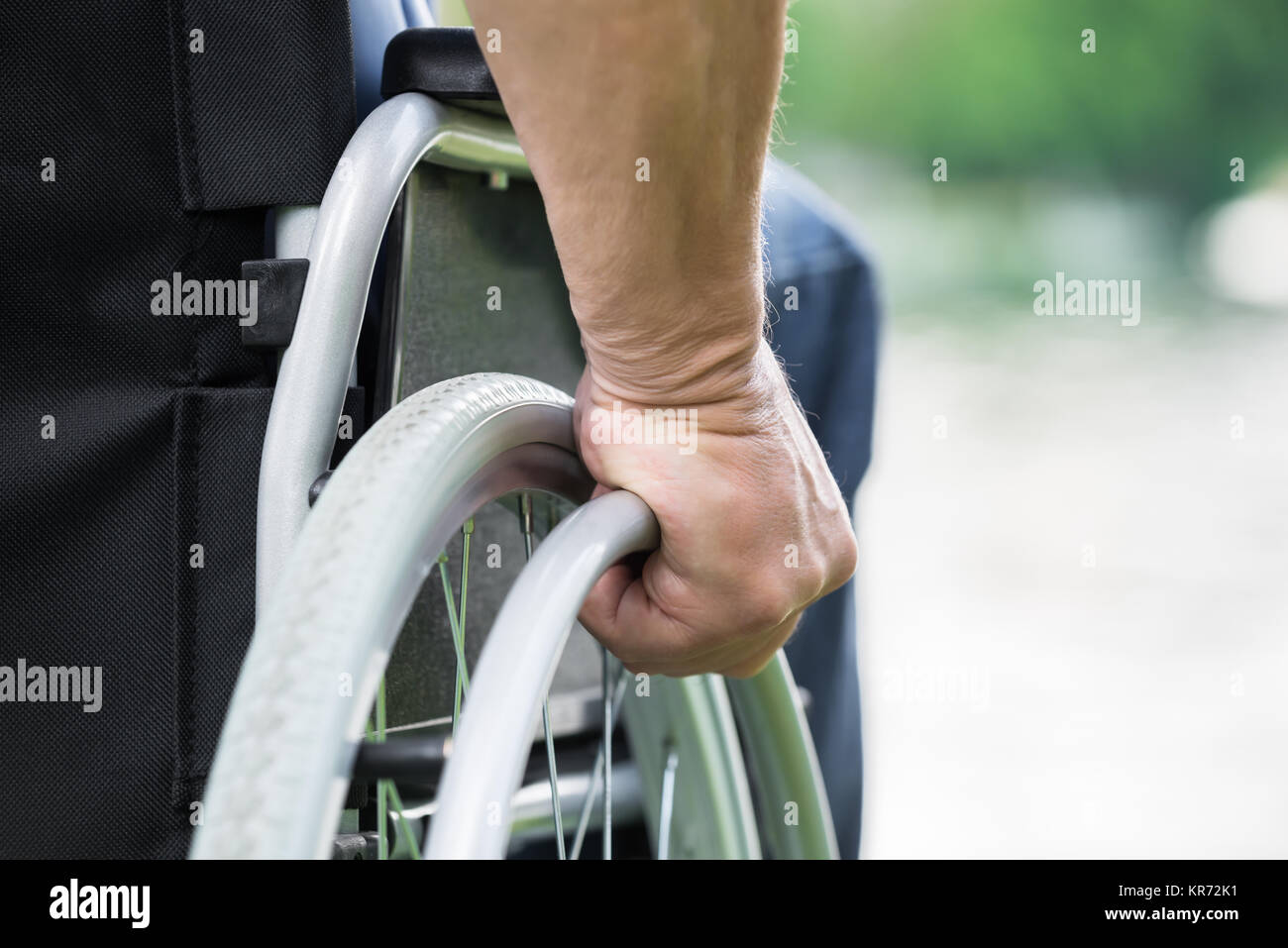 Disabled Man Pushing Wheel Of Wheelchair Stock Photo - Alamy