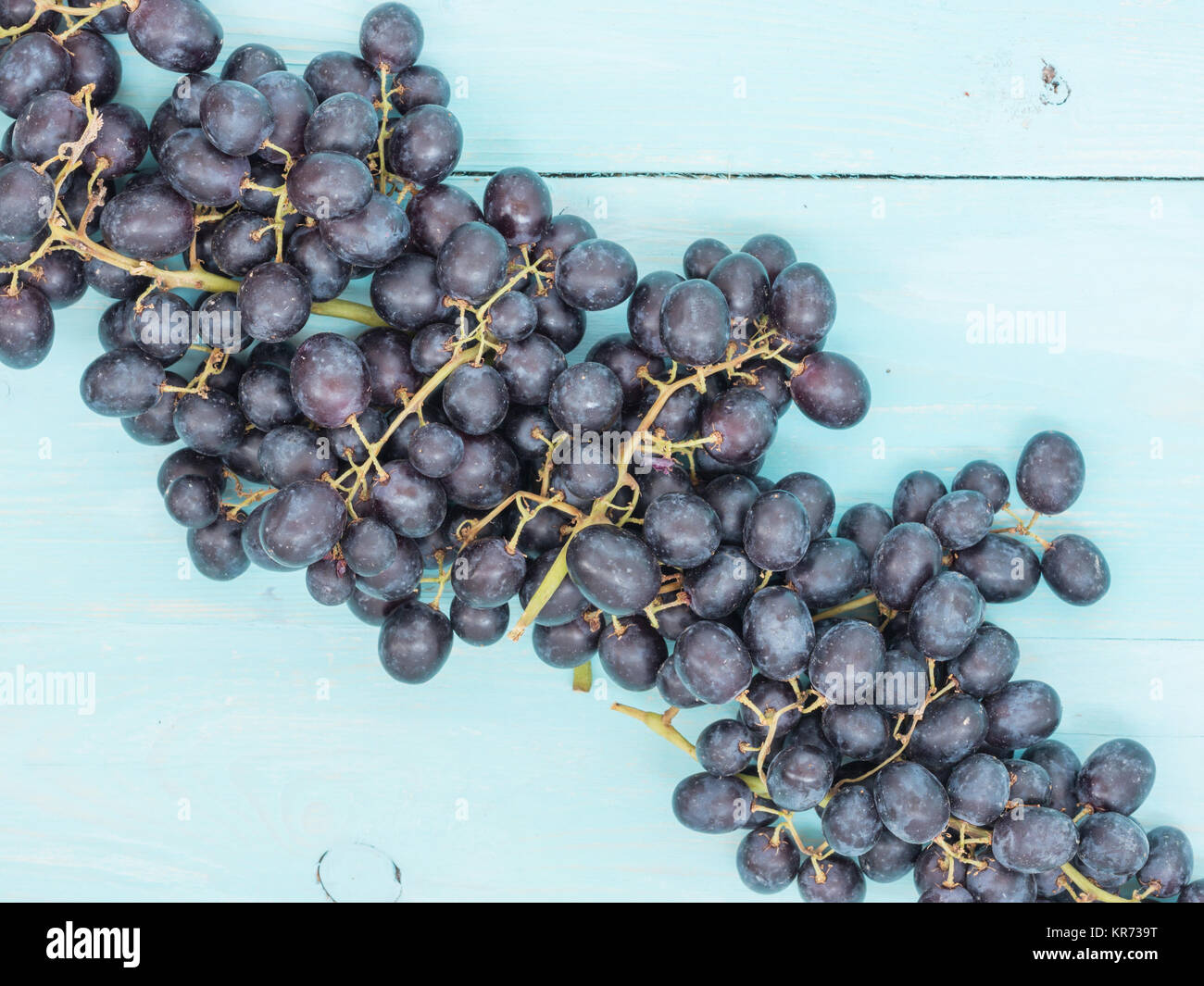 Purple grapes on wooden table Stock Photo - Alamy