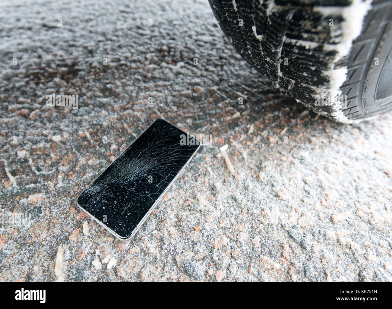 Phone with broken screen on snow in car trails Stock Photo - Alamy