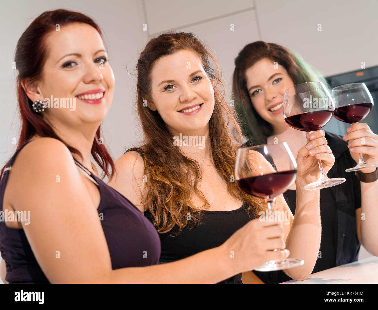 Three women making a toast with wine Stock Photo - Alamy