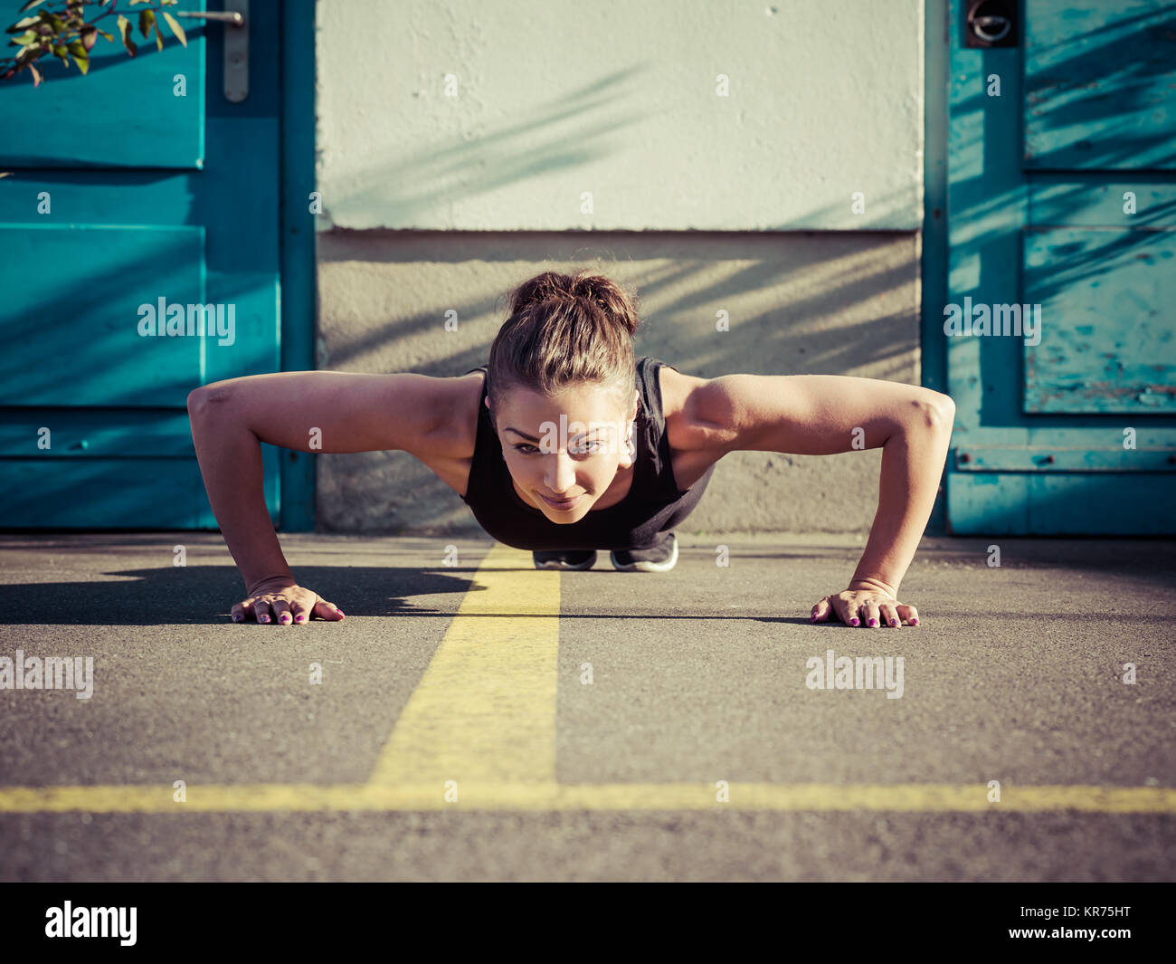 Young woman doing pushups outdoors Stock Photo - Alamy