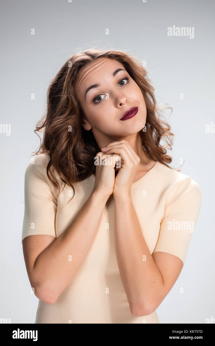 Woman is looking imploring over gray background Stock Photo - Alamy