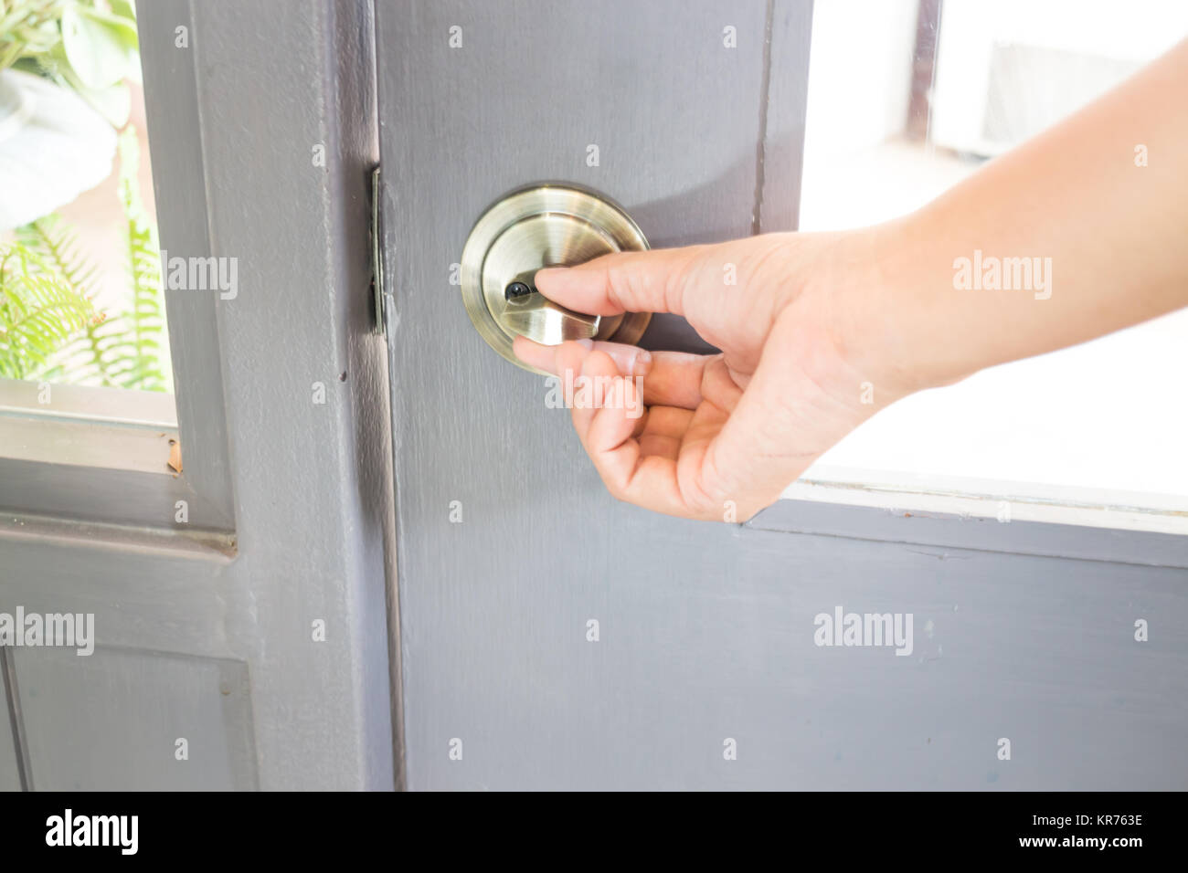Hand holding the door locker Stock Photo - Alamy