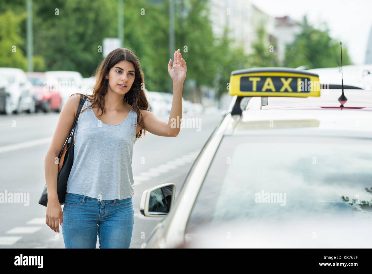 Woman Calling For Taxi On Street Stock Photo - Alamy