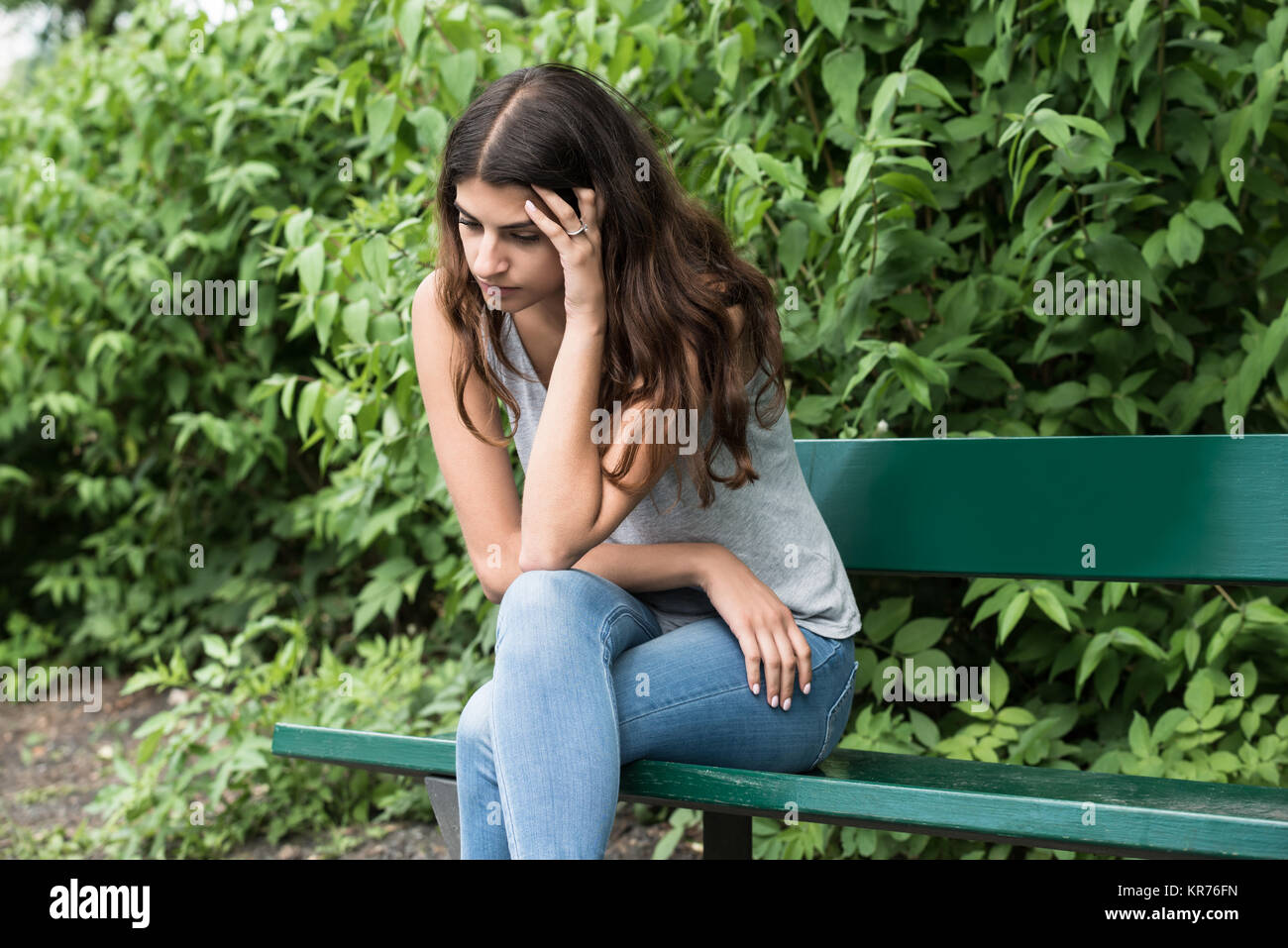 Sad Young Woman Sitting On Bench Stock Photo - Alamy