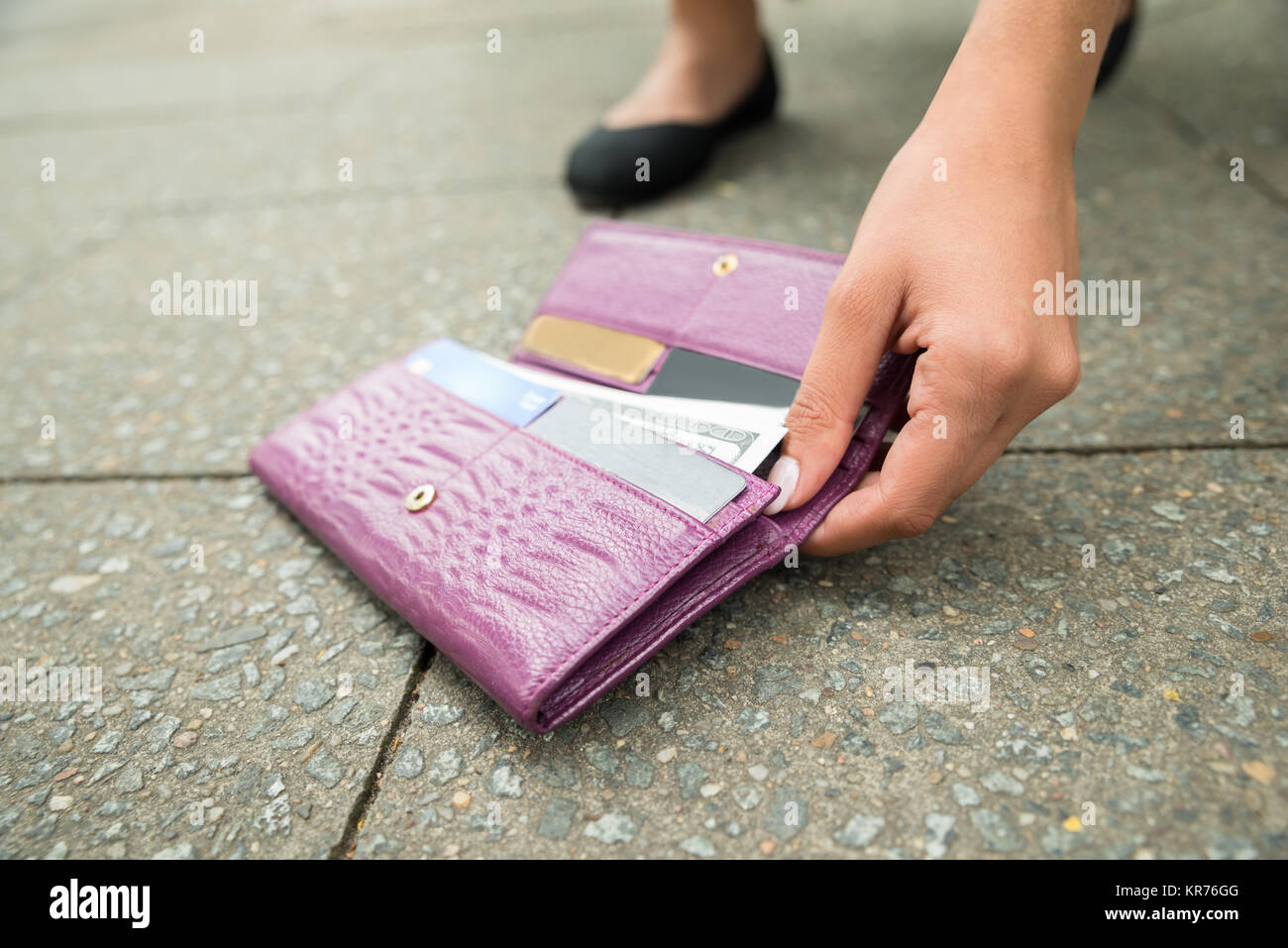 Woman Picking Up Fallen Wallet Stock Photo - Alamy