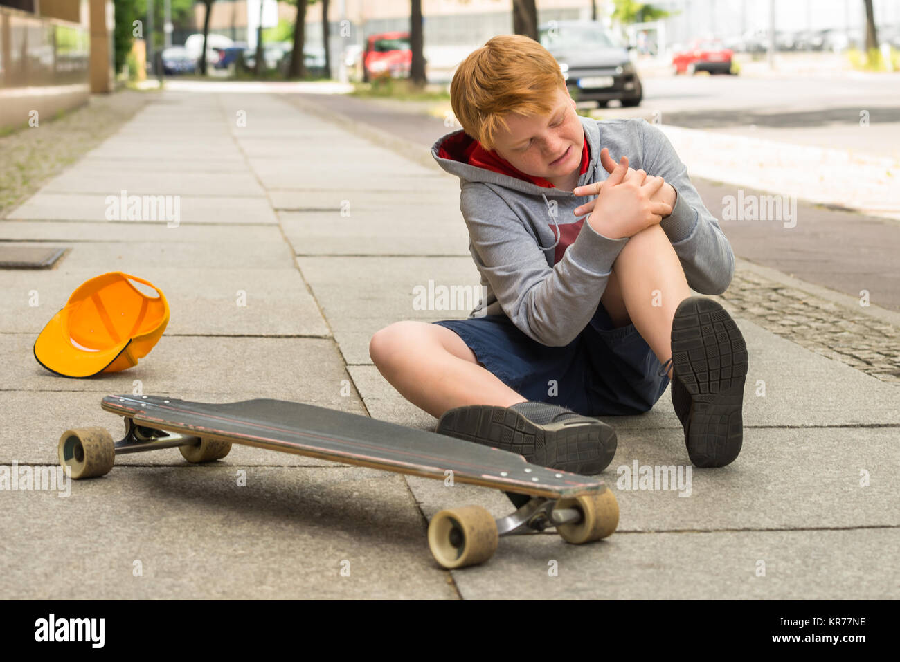 Boy Looking At His Injured Leg Stock Photo - Alamy