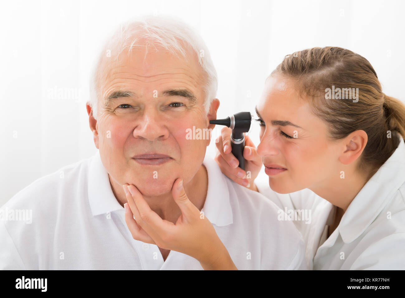 Doctor Looking At Patient's Ear Through Otoscope Stock Photo - Alamy