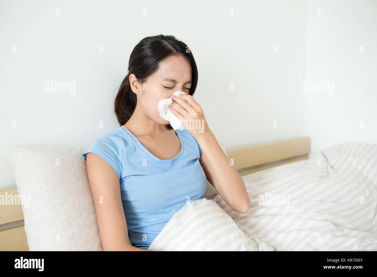 Woman runny nose and resting on bed Stock Photo - Alamy