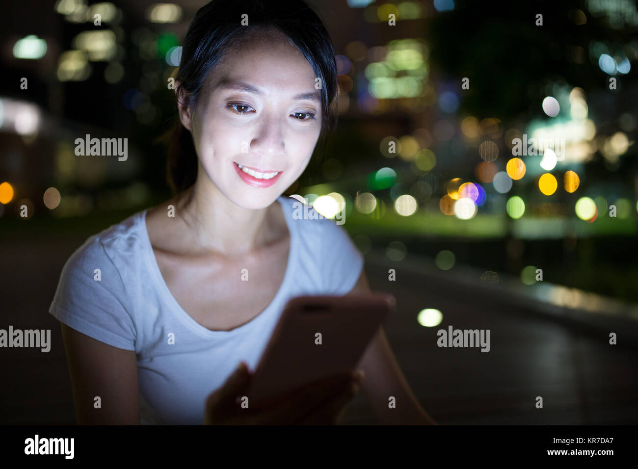 Woman using cellphone at night Stock Photo - Alamy