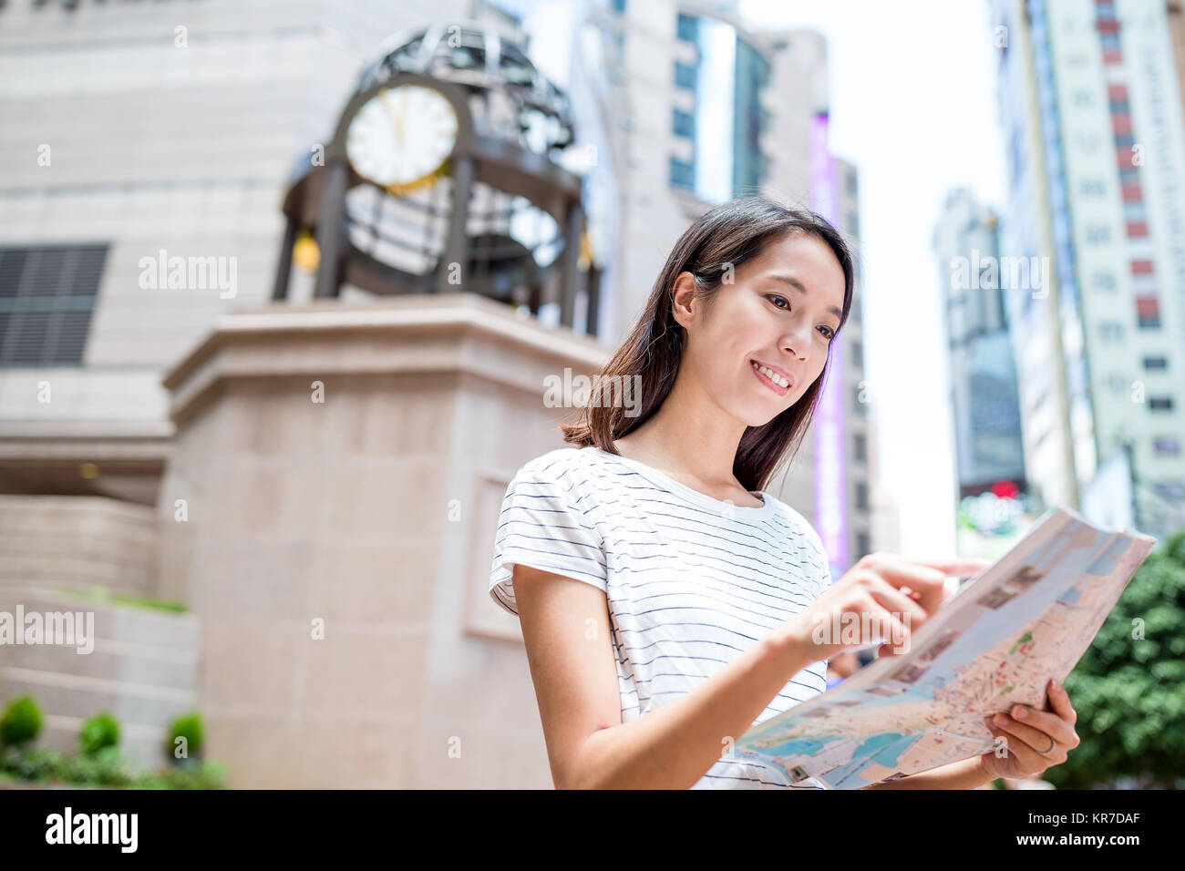 Asian woman reading on city map Stock Photo - Alamy