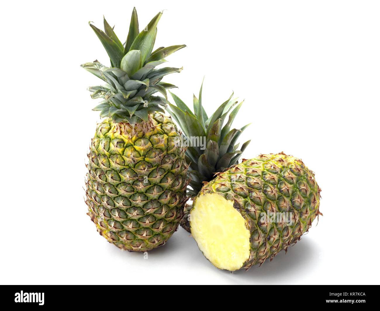 two pineapples on white showing one cut Stock Photo - Alamy