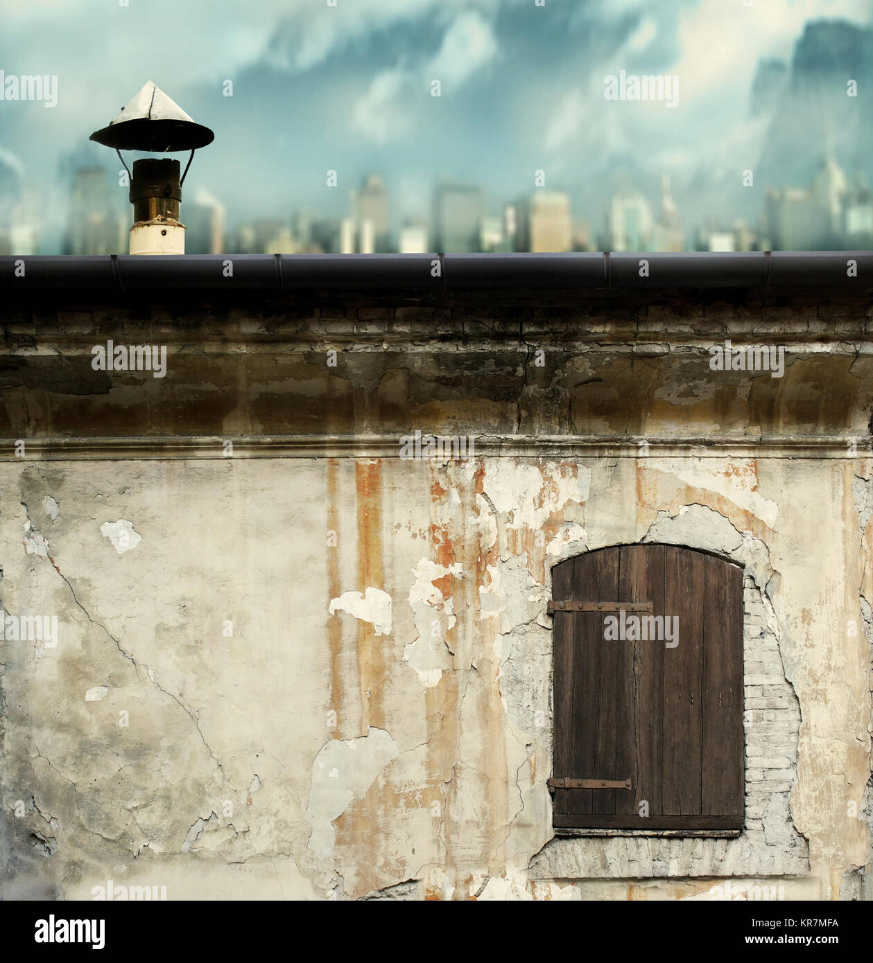 Detail of an old grungy facade and roof of a building with a city and ...